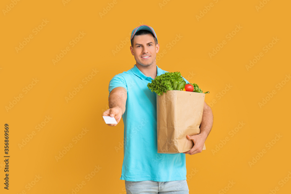 Delivery man with food in bag and business card on color background ...