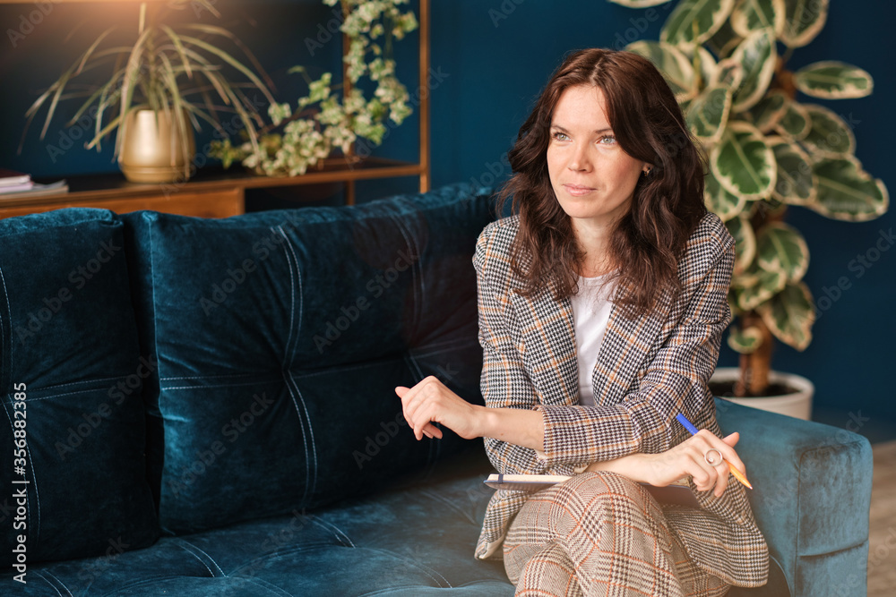 Beautiful happy woman brunette psychologist listens and speaks with a ...