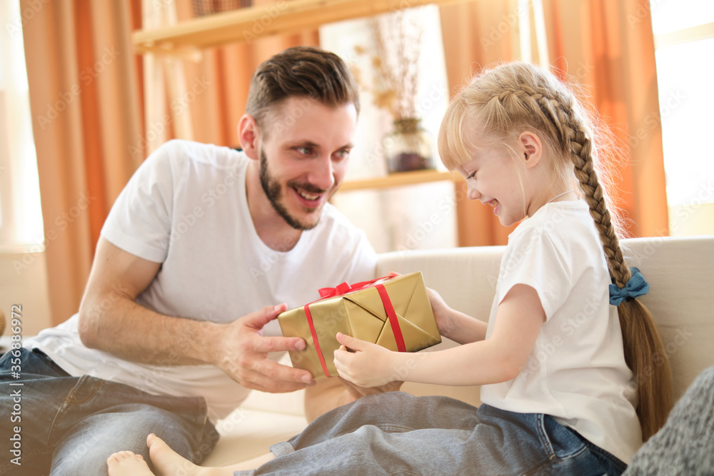 Foto de Father and daughter. Handsome young man gives a gift or present ...