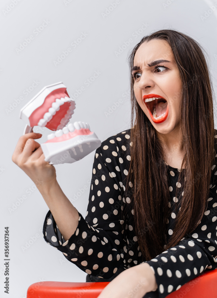 Funny scared girl of a opened dental jaw near face. Woman toing with ...