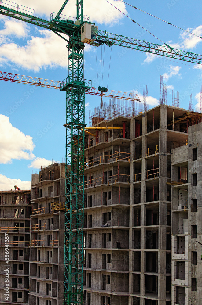 The tower crane is fixing with the metal elements to the building. View ...