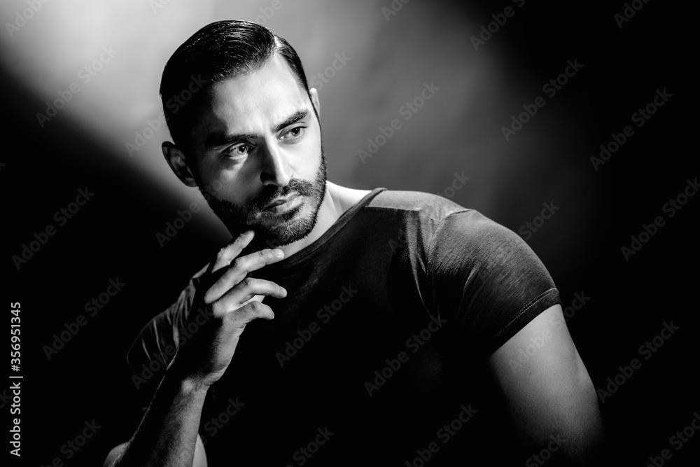 Black and white portrait of strong muscular thoughtful man touching ...