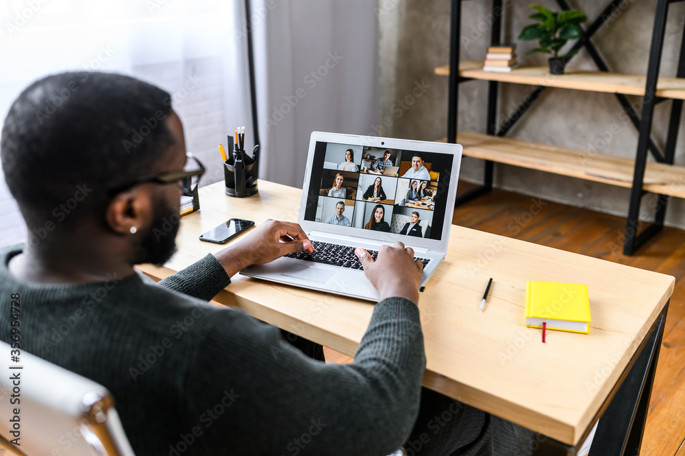 Virtual meeting with many people together. African-American young guy ...