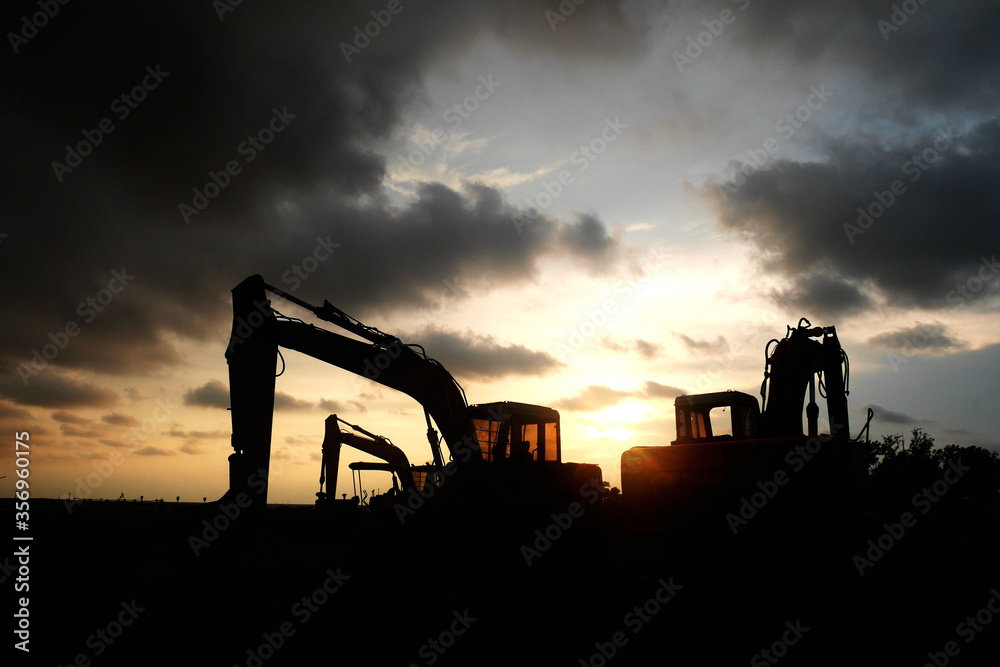 Backhoe was digging earthmoving work at construction site on sunset ...