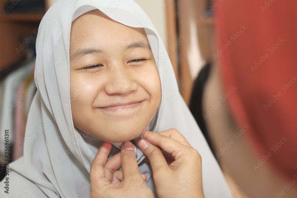 Muslim girl wearing hijab with the help of her mother, islam religion ...