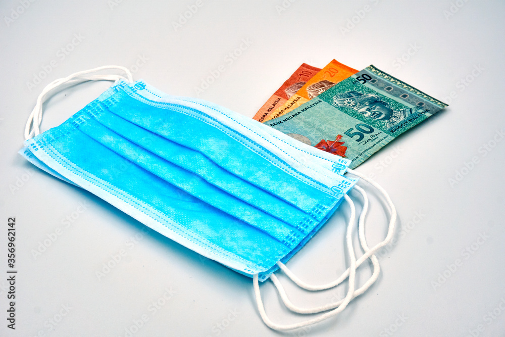 Surgical face mask and bank notes over white background Stock Photo ...
