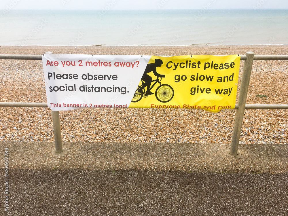 A banner on seafront promenade railings asks cyclists to go slow and ...