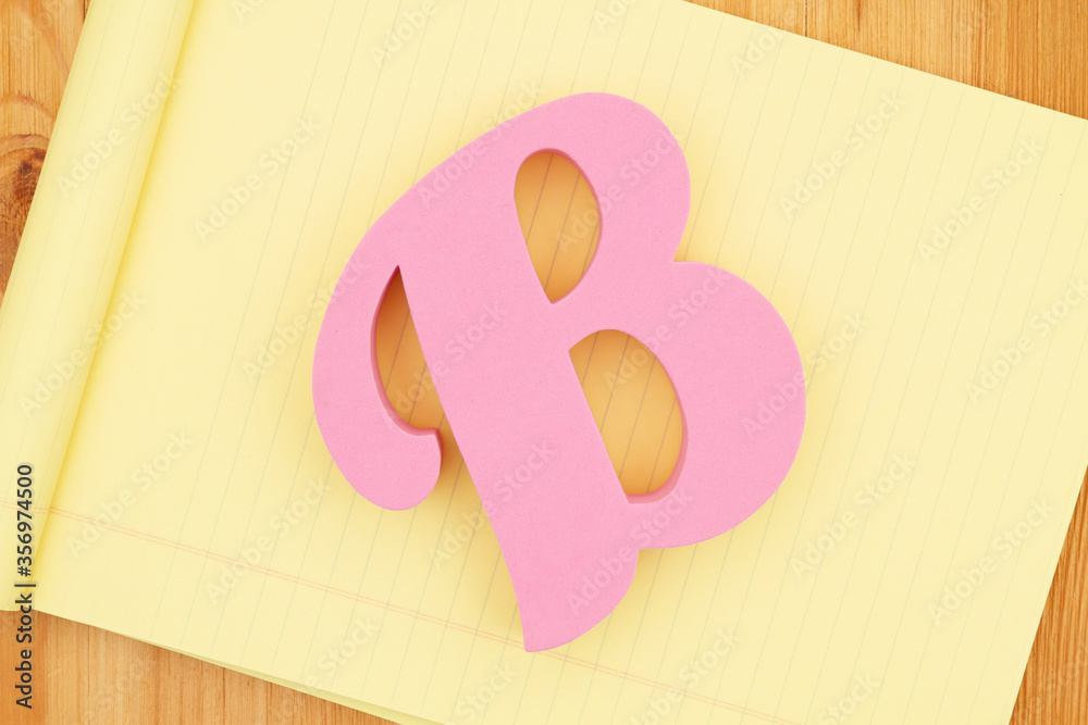 Capital pink letter B on yellow lined paper Stock Photo | Adobe Stock