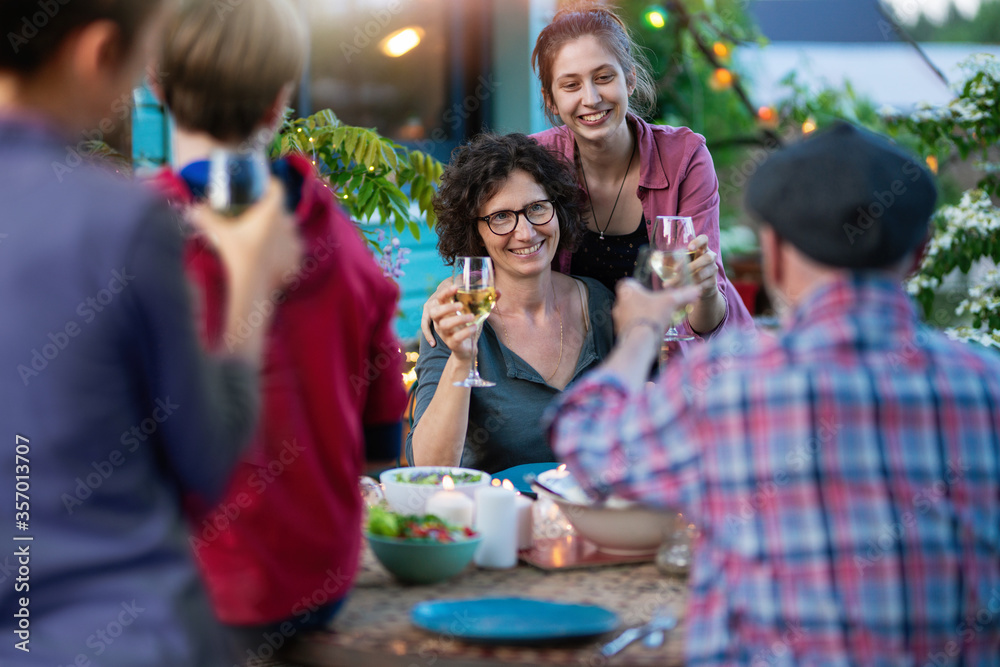 in the evening, dinner with the family around a table in the garden, in ...