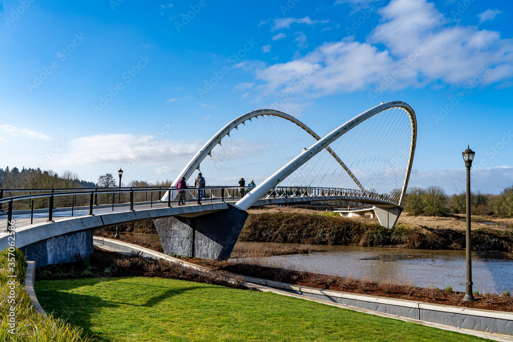 People walking on the Peter Courtney Minto Island Bridge, it connects ...