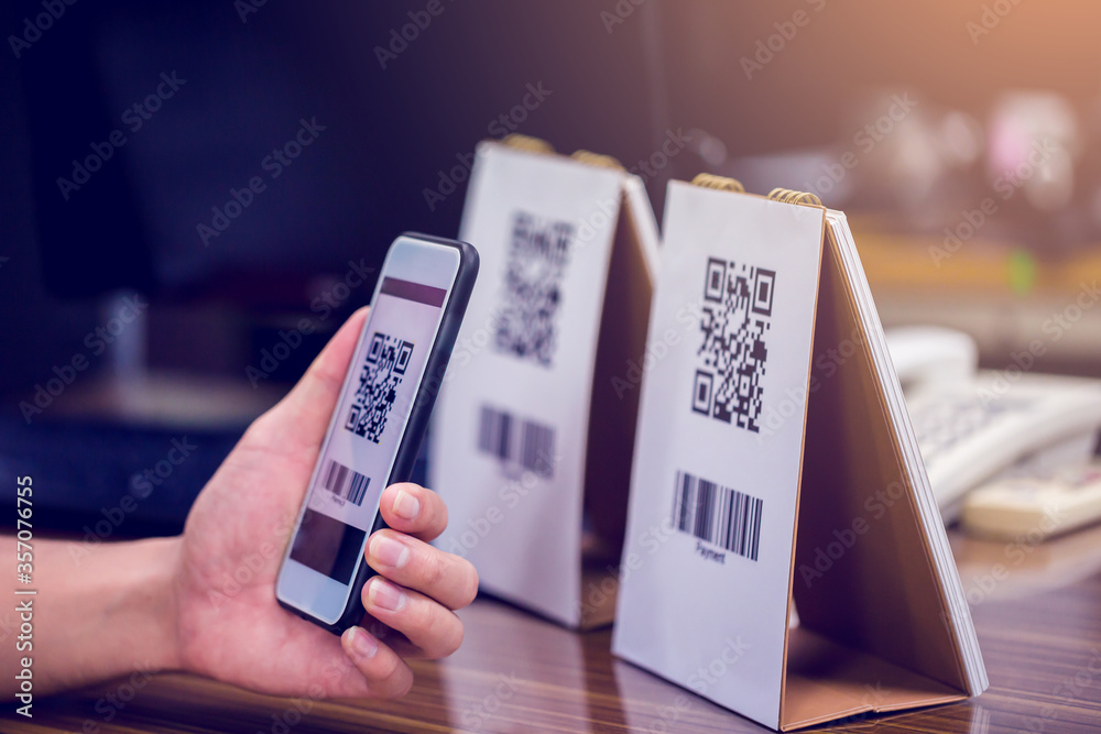 Closeup of a hand holding phone and scanning qr code. Man hand paying ...