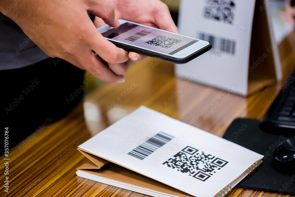 Closeup of a hand holding phone and scanning qr code. Man hand paying ...