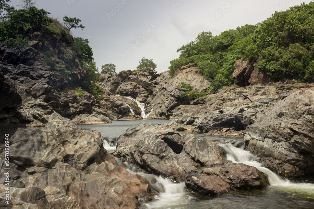 A milky water stream flowing silently amidst rocky ravines with the ...