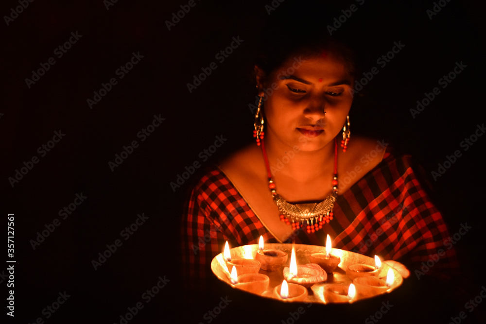 Beautiful Hindu Indian young women lightening deepa on Diwali day Stock ...