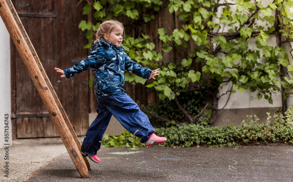 Elegant body posture in the air. Child hops from step ladder. Girl ...