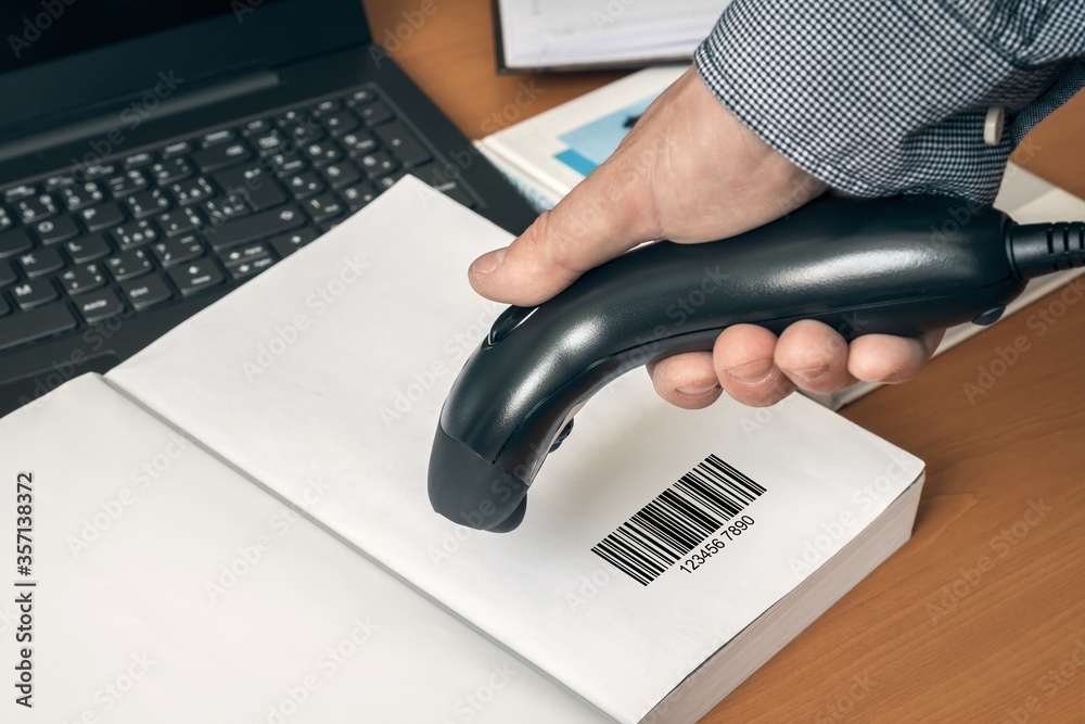 Man with scanner scans barcode in a book Stock Photo | Adobe Stock
