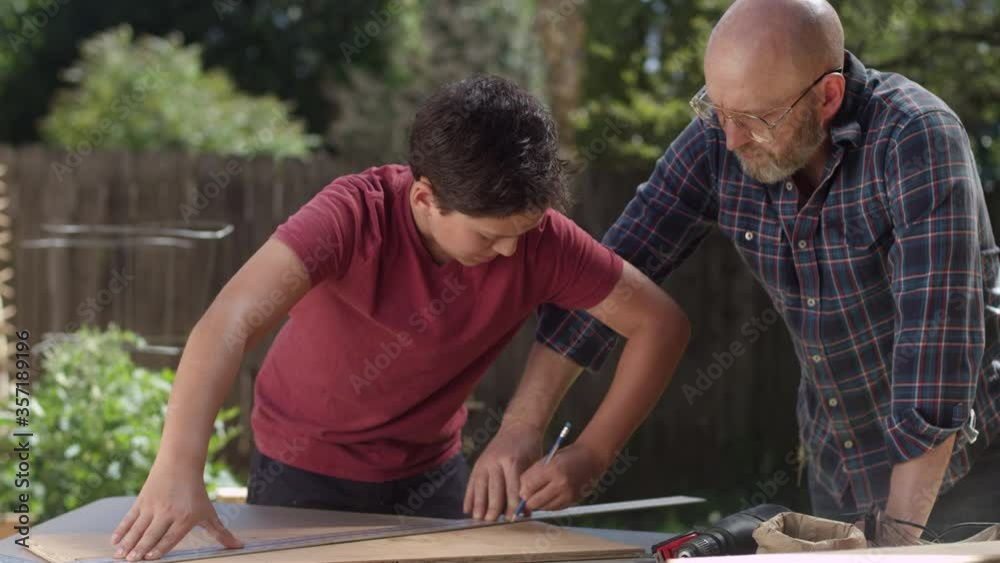 Vidéo Stock Father helps his son on a DIY backyard construction project ...