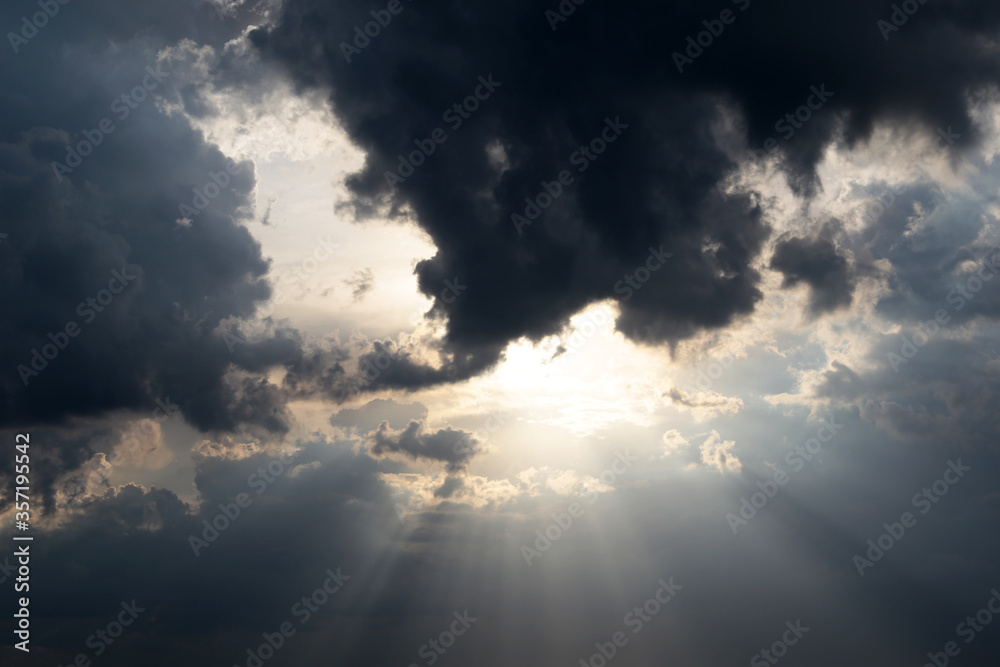Sky covered with storm clouds, sun rays shines through the dark ...