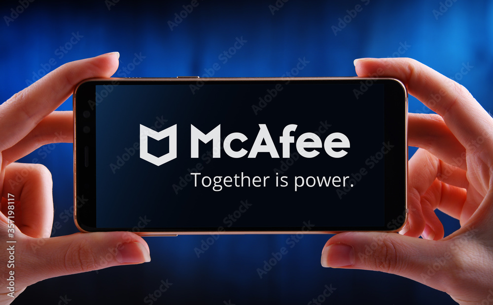 Hands holding smartphone displaying logo of McAfee Stock Photo | Adobe ...