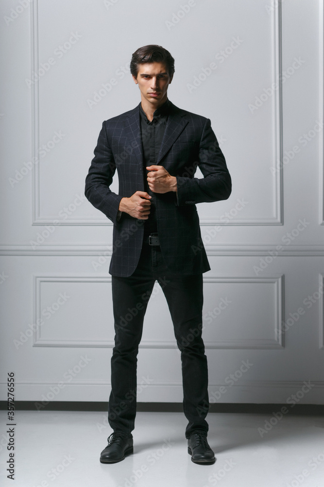 Vertical view. Full length picture of an elegant young man adjusting ...