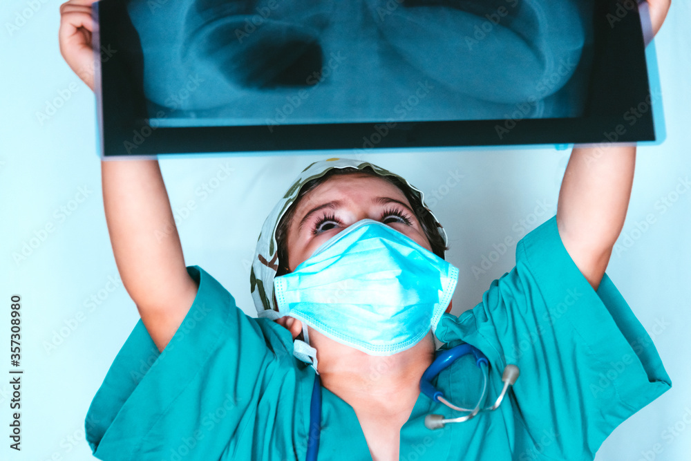 cute kid playing doctor dressed as a surgeon examining an x-ray Stock ...