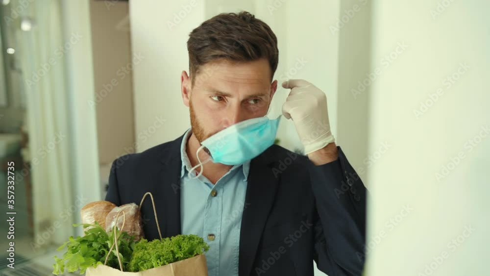 Attractive stylish man coming back home after food shopping entering ...