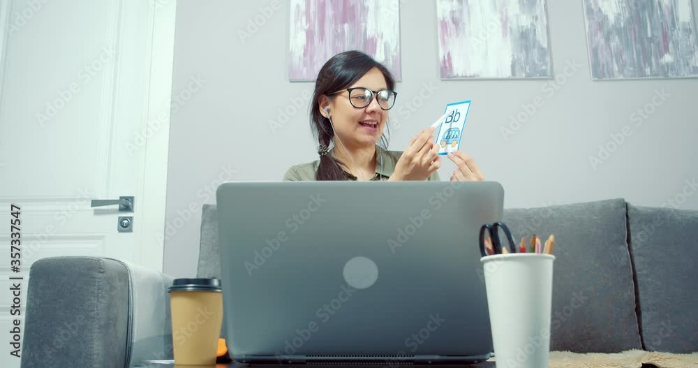 Young woman teacher showing picture with the alphabet, learning letters ...
