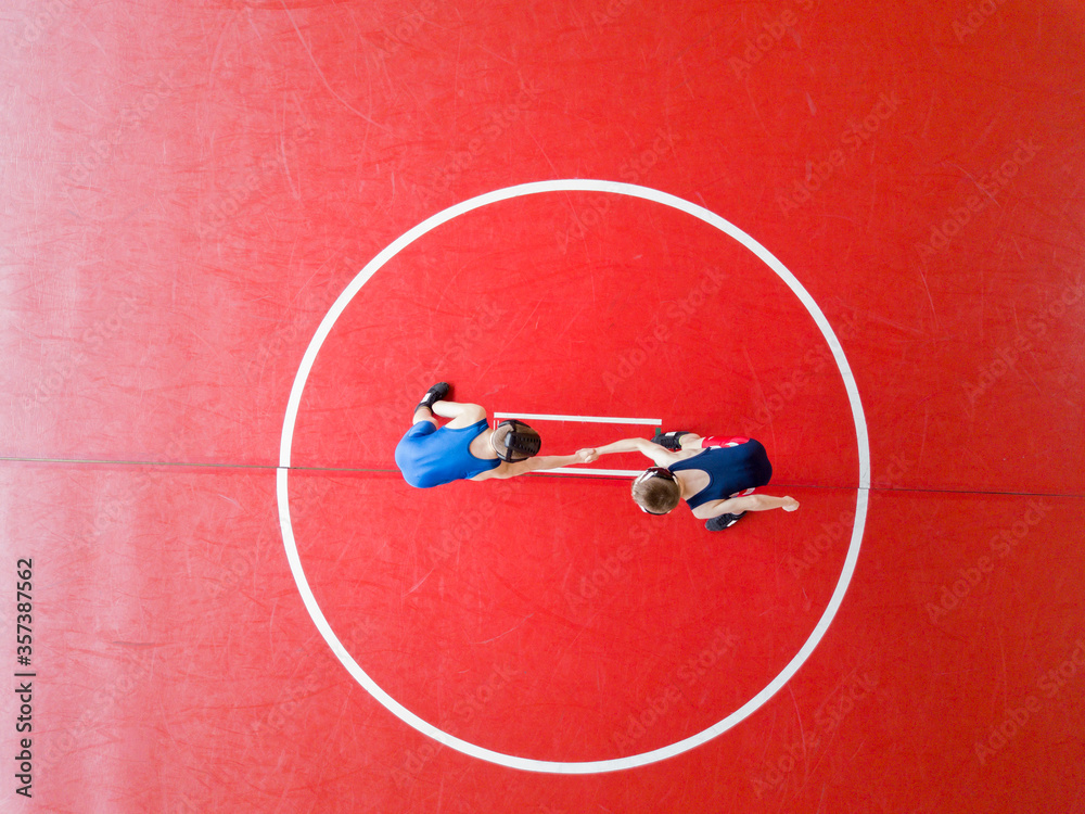 Aerial view of two wrestlers competing on a red wrestling mat. Stock ...