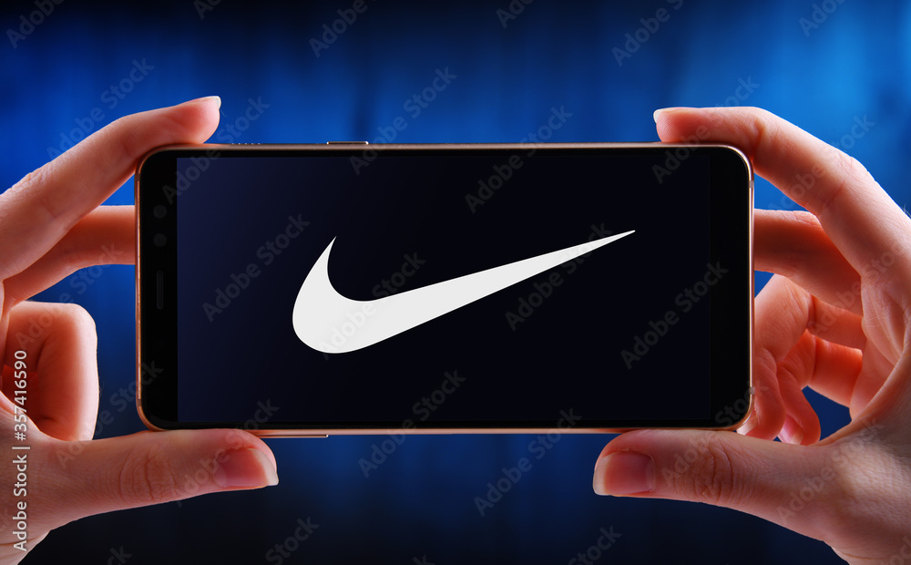 Hands holding smartphone displaying logo of Nike Stock Photo | Adobe Stock