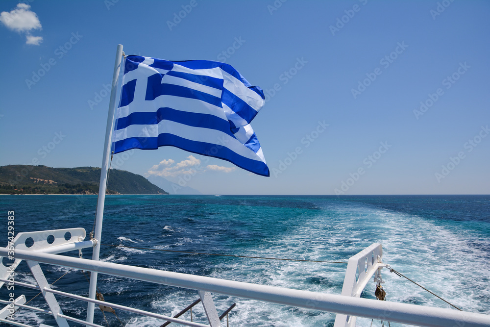 Greek flag on board a cruise boat travelling along Mount Athos ...