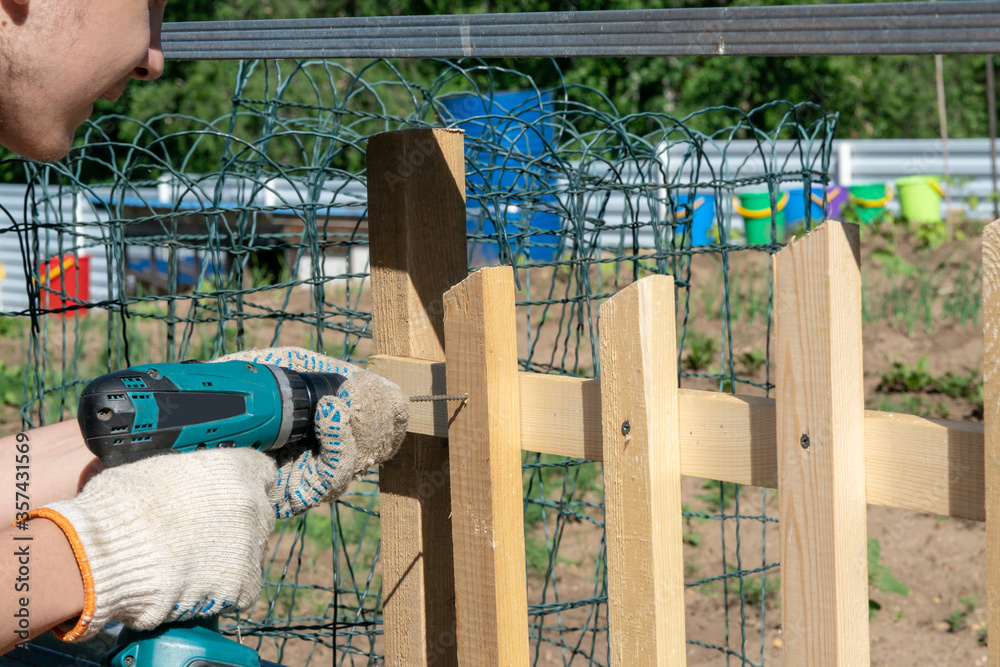 Building a wooden fence with a screwdriver. Natural eco-friendly ...