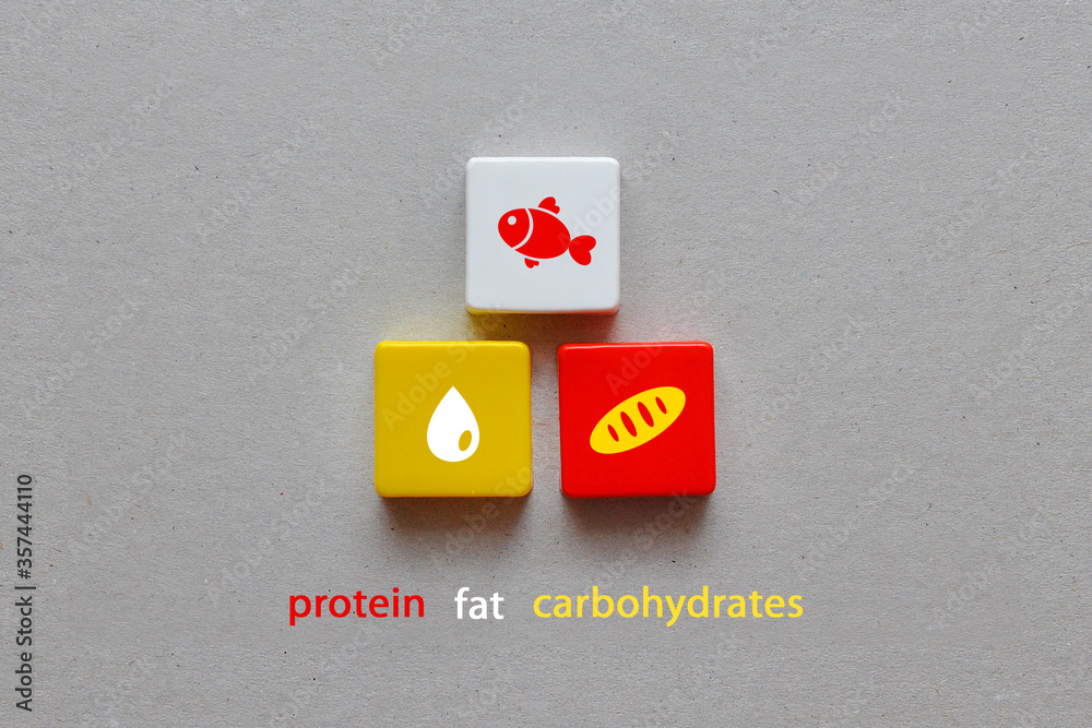 A set of colorful cubes with icons of proteins, fats and carbohydrates ...