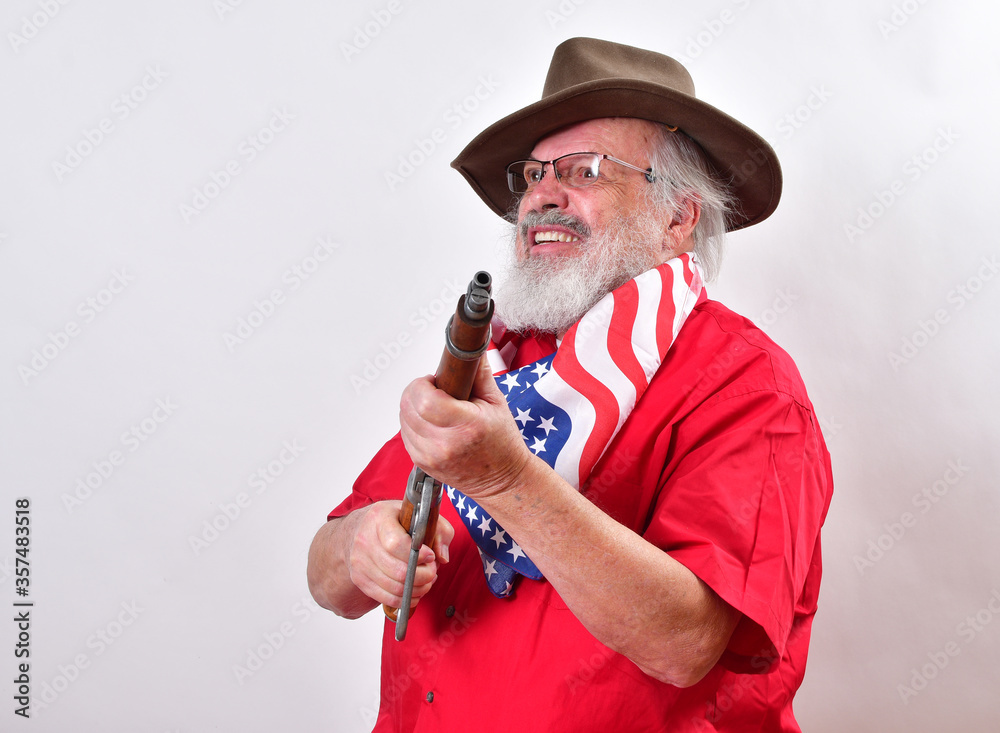 Happy, smiling old man, armed with a sawed off rifle, wearing patriotic ...