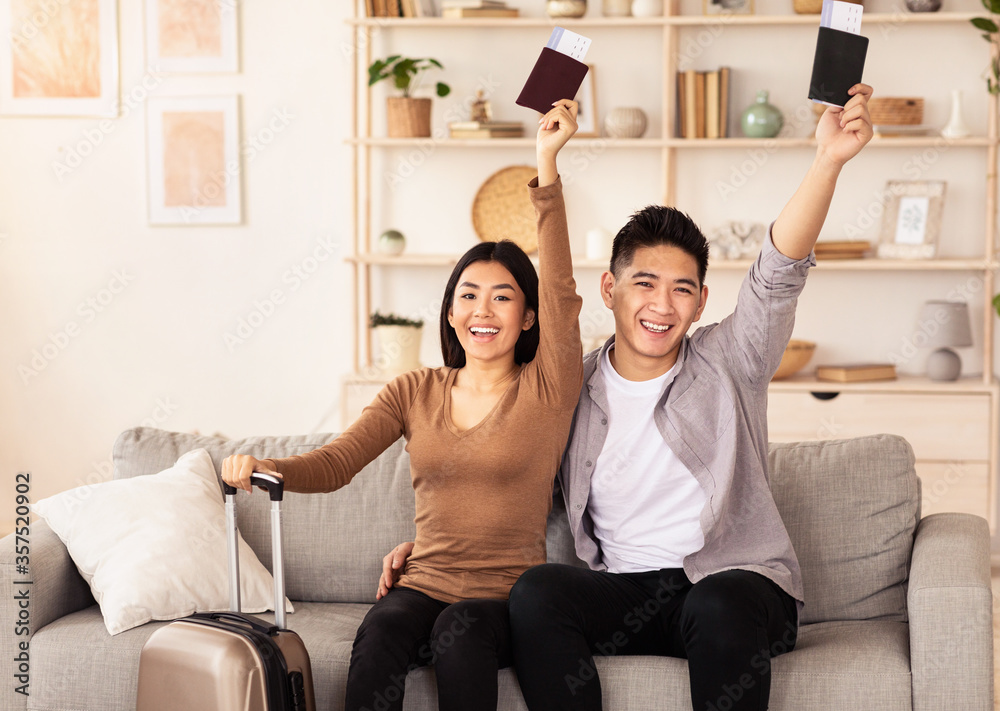 Spouses Raising Hands With Tickets Sitting On Sofa At Home Stock Photo ...