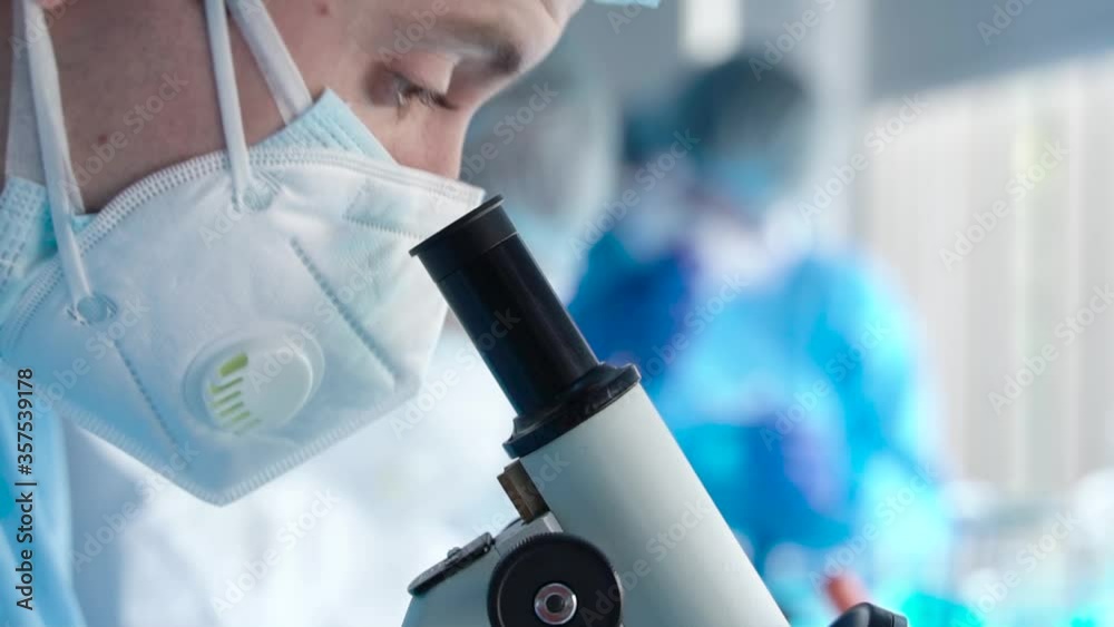 scientist or researcher in laboratory looking into microscope Stock ...