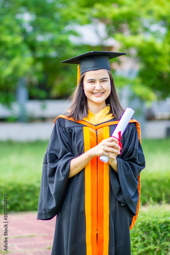 Graduation girl raises her hand to celebrate her graduation, complete ...
