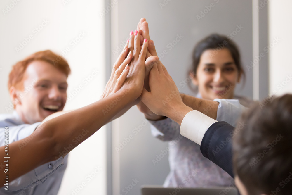Happy diverse employees giving high five close up, celebrating teamwork ...