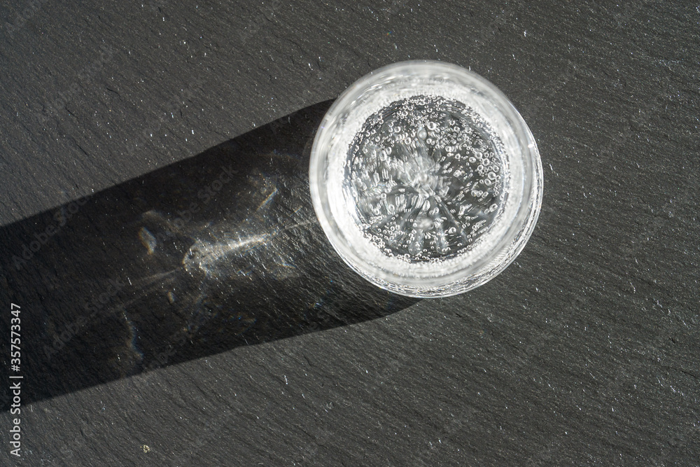 Cold summer delicious mineral water in a crystal glass on the black ...