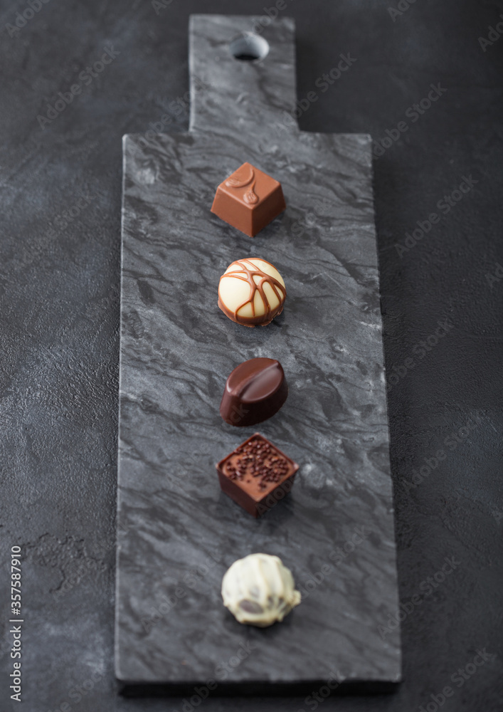 Luxury Chocolate candies selection on black marbel board. White, dark ...