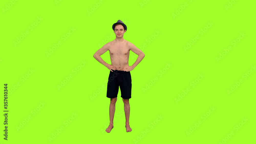 Young man posing and showing his muscles on green screen background ...