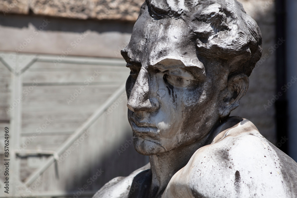 Close up. A statue of a man (a male head) made of white marble in a ...