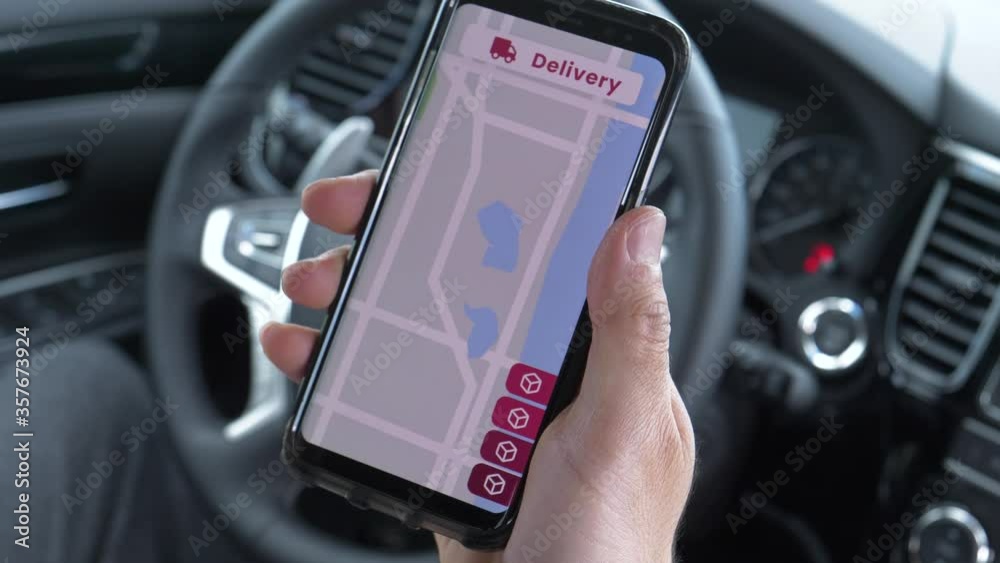 Sitting inside a car a delivery driver checking the order he has to ...