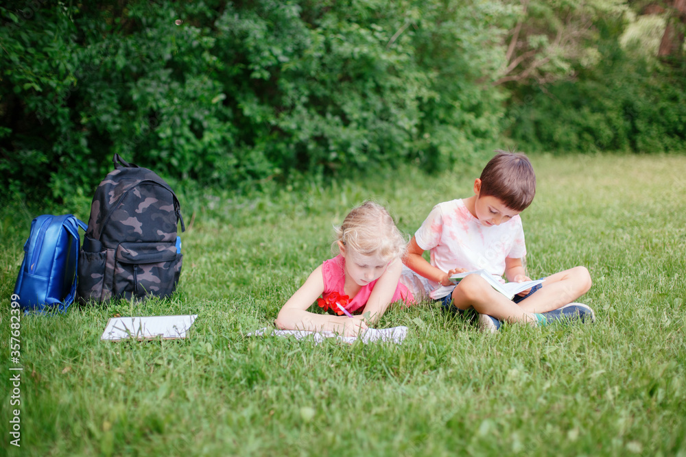 Young Caucasian school girl and boy friends doing school homework in ...