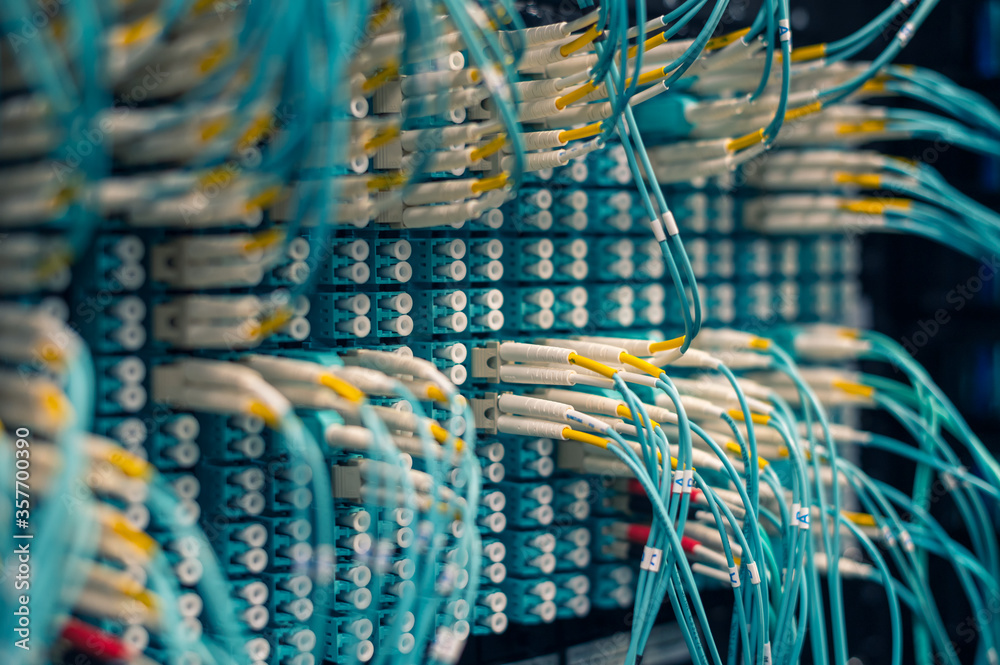 Fiber optic cables and connectors in a data center network patch panel ...