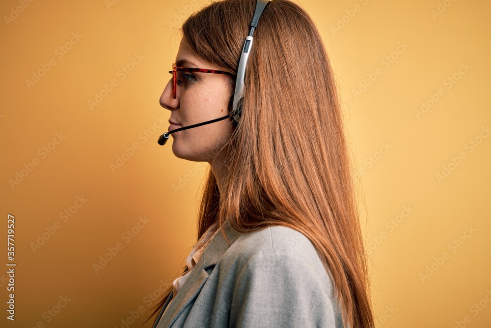 Young redhead call center agent woman overworked wearing glasses using ...