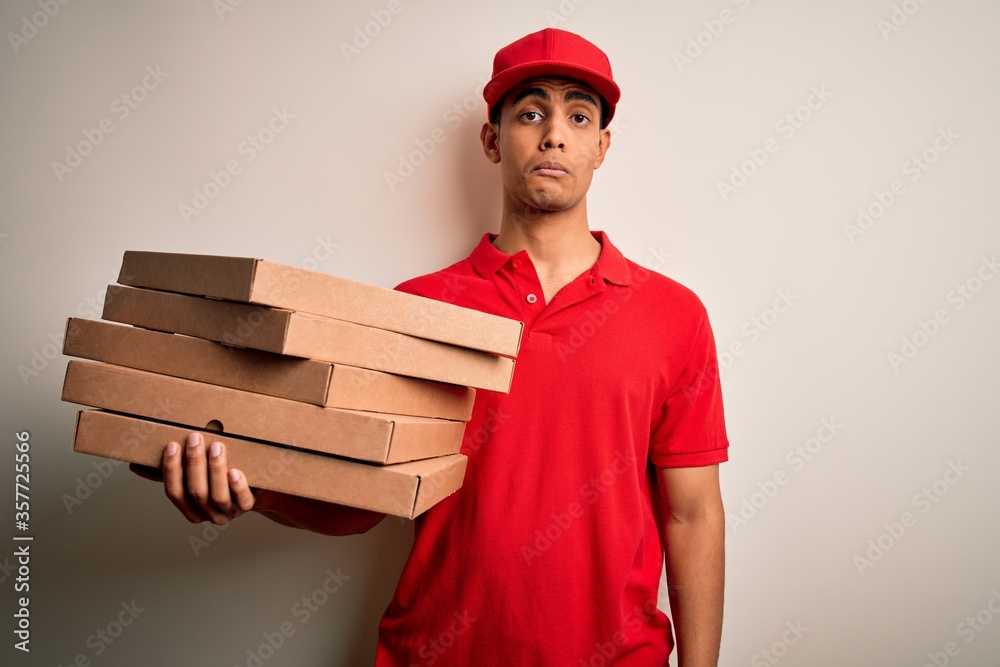 Handsome african american delivery man holding boxes of italian pizza ...