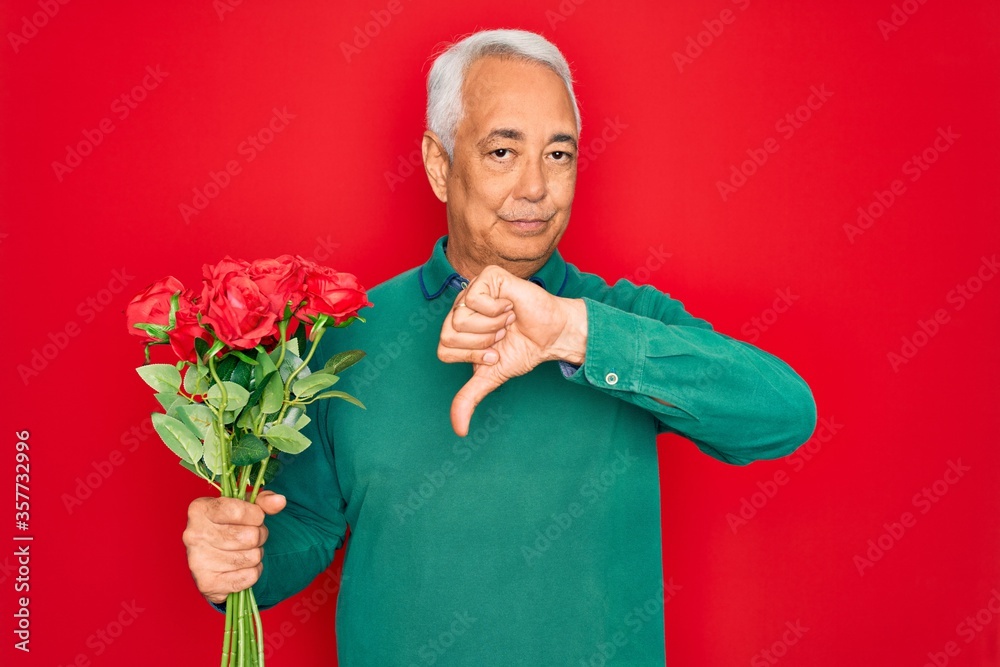 Middle age senior grey-haired man holding romantic bouquet of red roses ...