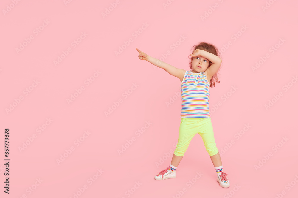 Challenges for children. Child girl model in full growth on a pink ...