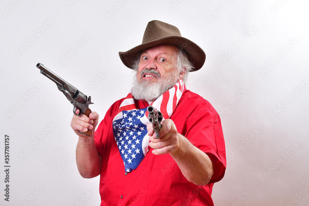 A Western rancher wearing a patriotic bandana has two pistols with one ...