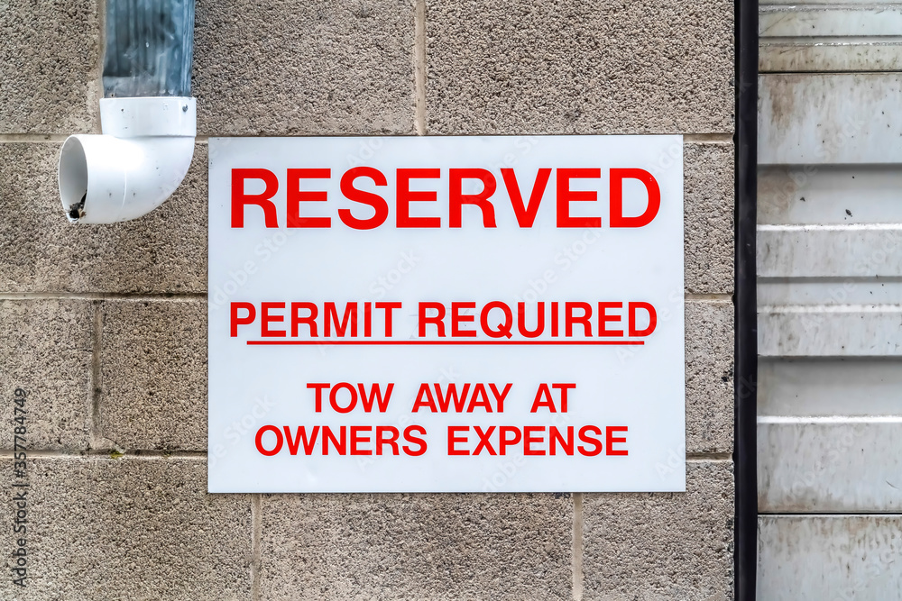 Reserved sign and downspout against wall of building and corrugated ...